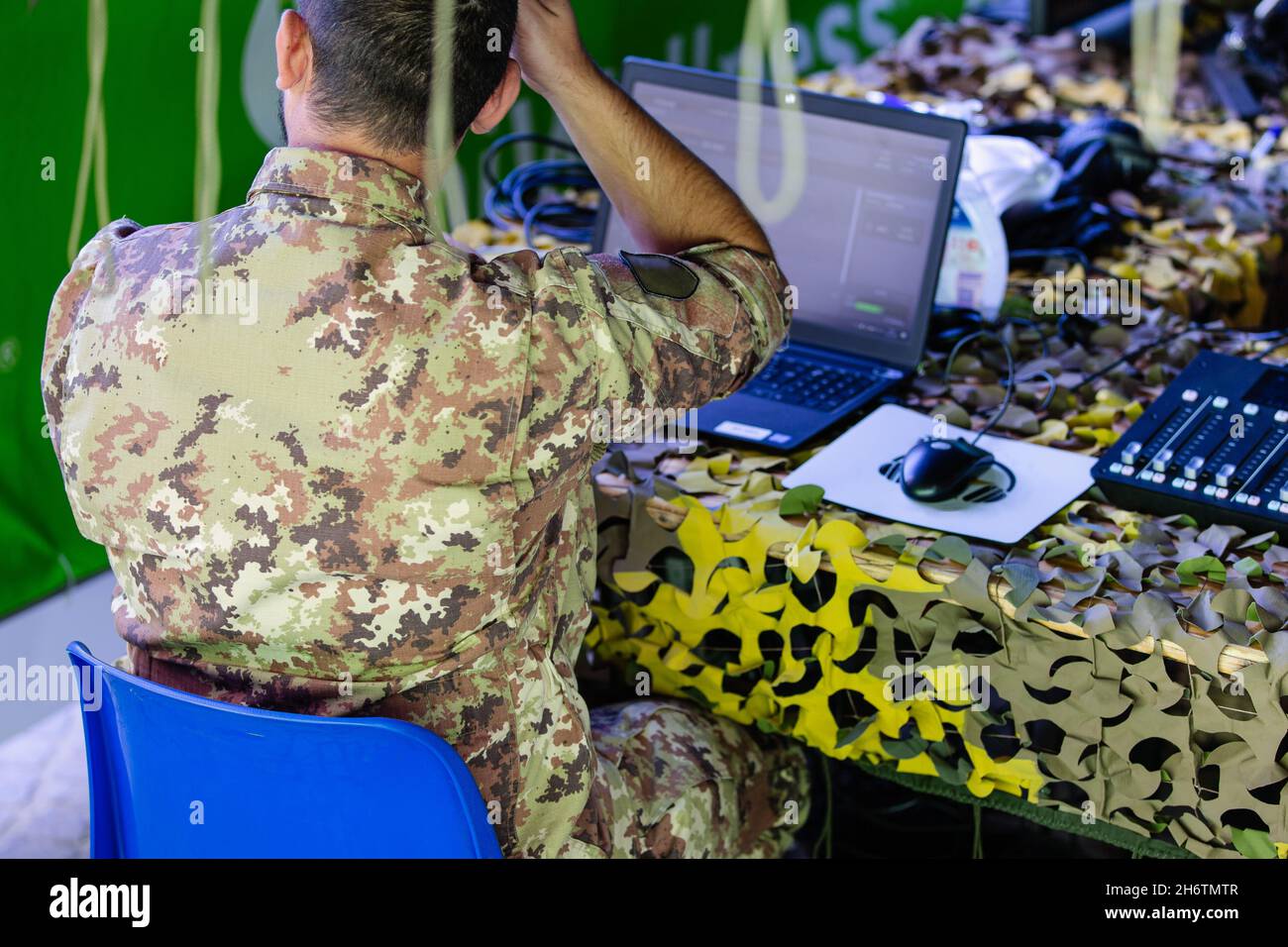 Data Entry Soldier with a laptop in Front of him inside a Military Camp ...