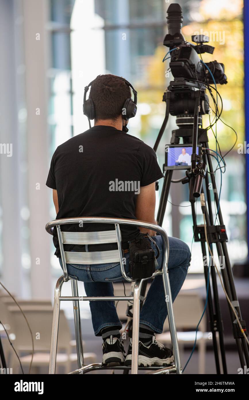 Camcorder Operator filming Live Show sitting on a Chair Stock Photo - Alamy