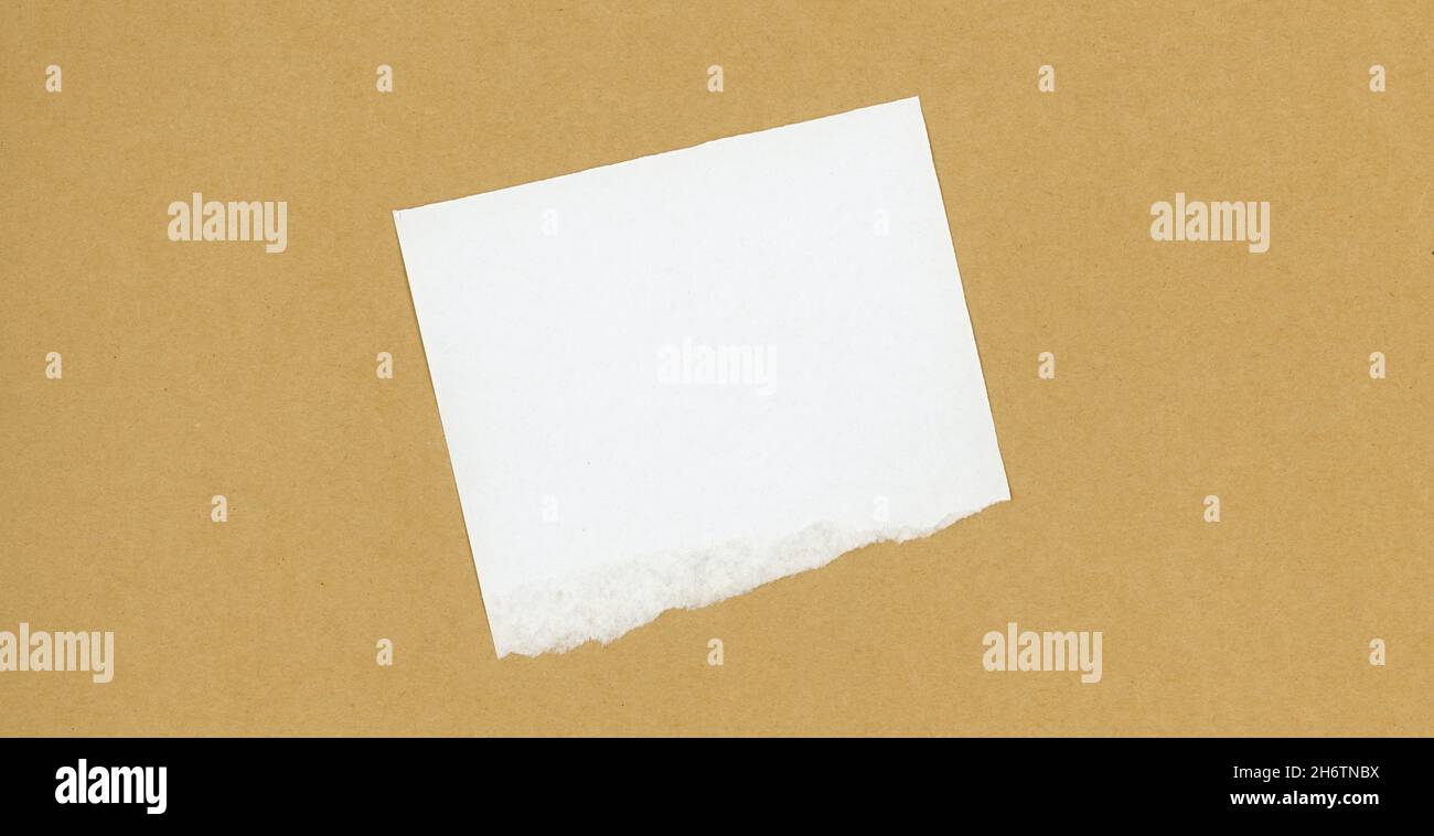 blank white slip of paper with copy space over brown cardboard ...