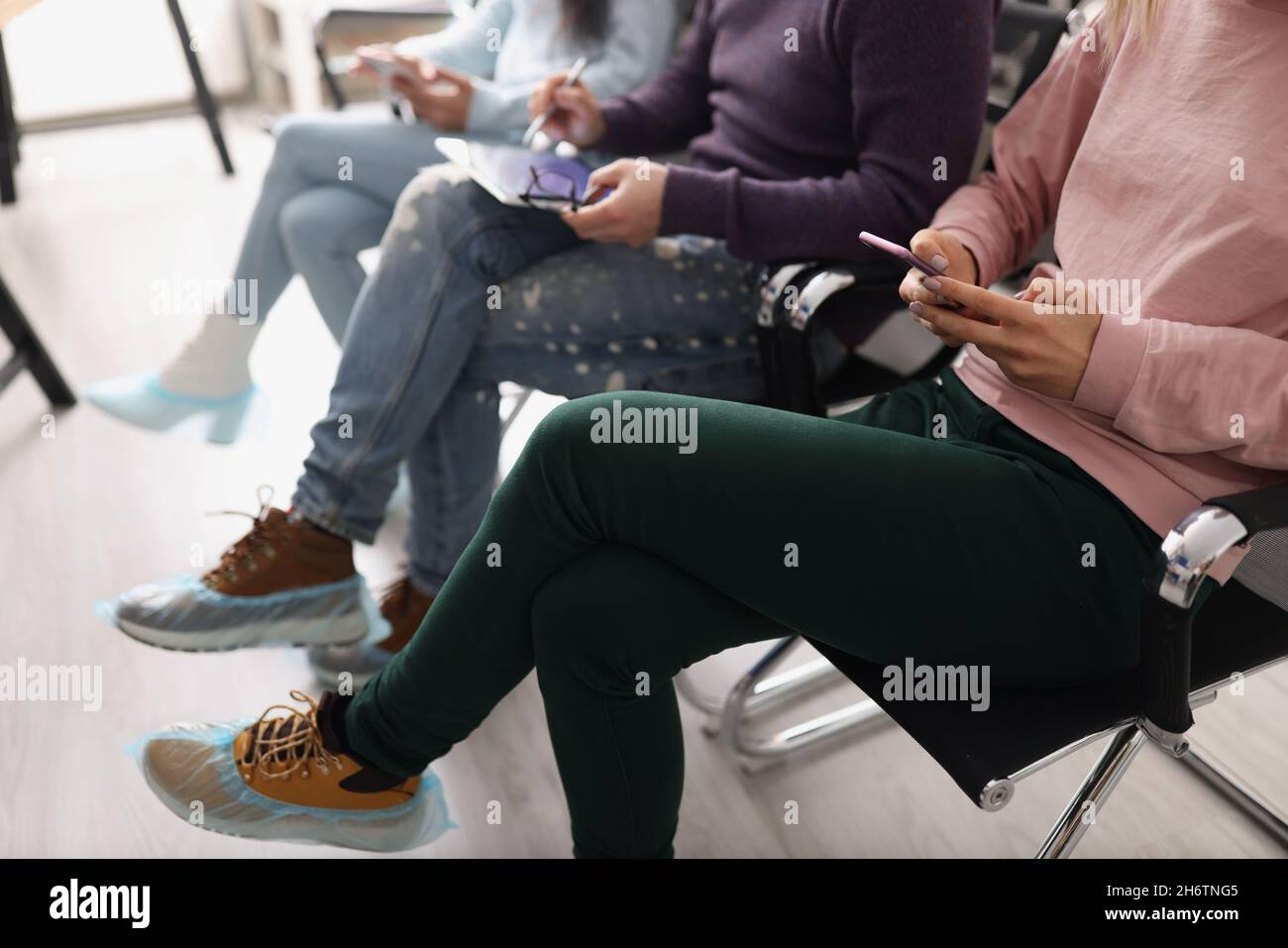 People sitting in line and surfing gadgets Stock Photo - Alamy