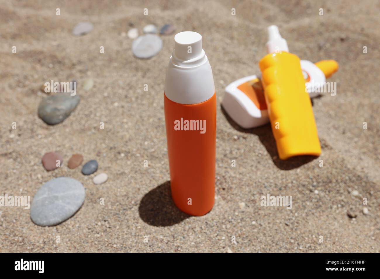 Sunscreens in colourful unbranded bottles on sand Stock Photo - Alamy