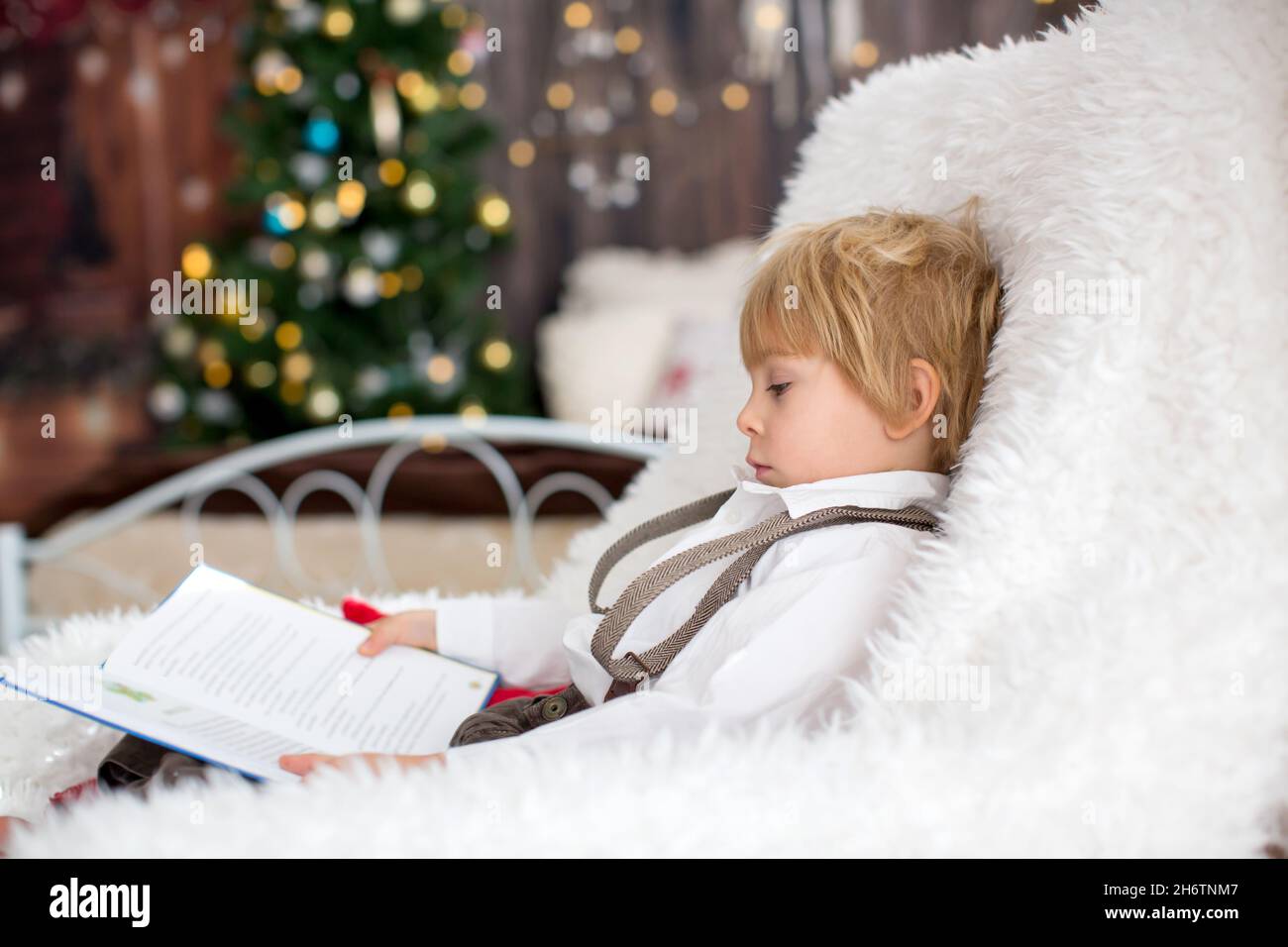 Little boy reading in armchair hi-res stock photography and images - Alamy