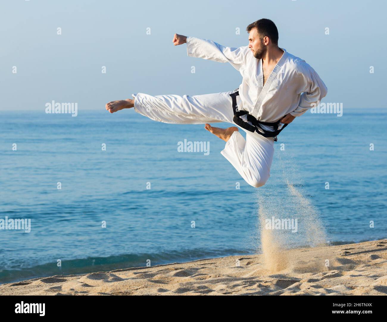 Guy practising karate at seaside Stock Photo - Alamy
