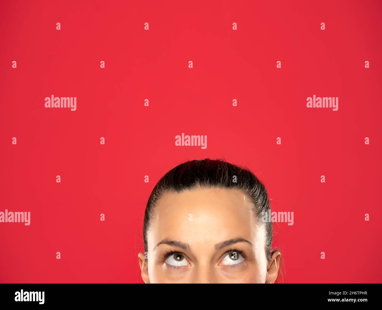 half portrait of a young woman looking up on red background Stock Photo ...