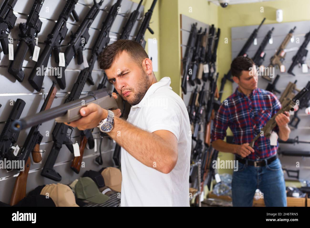Friends choosing air-powered gun Stock Photo - Alamy