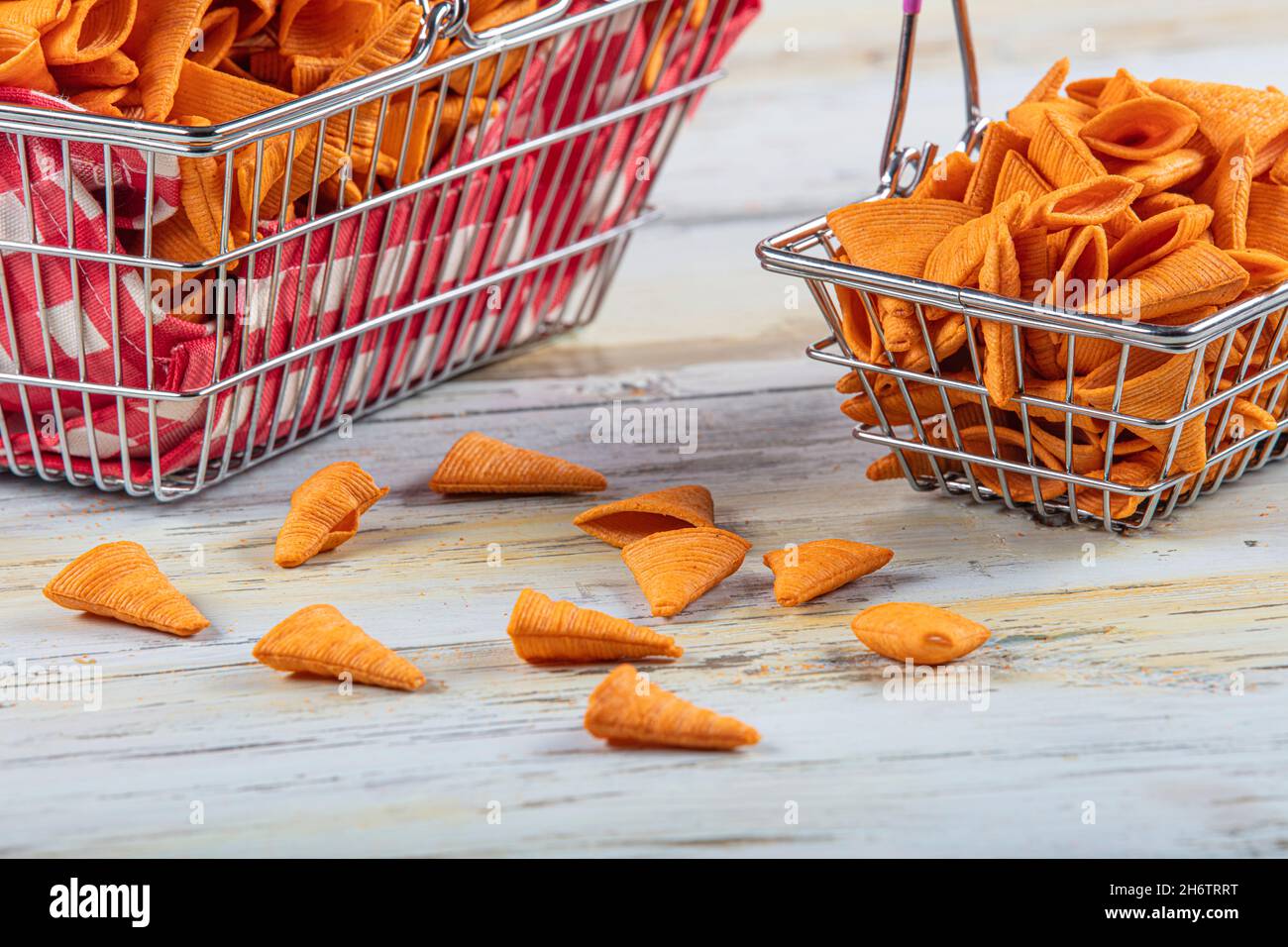 Portion of cone shaped snack tornado shaped crackers. Yellow spicy ...