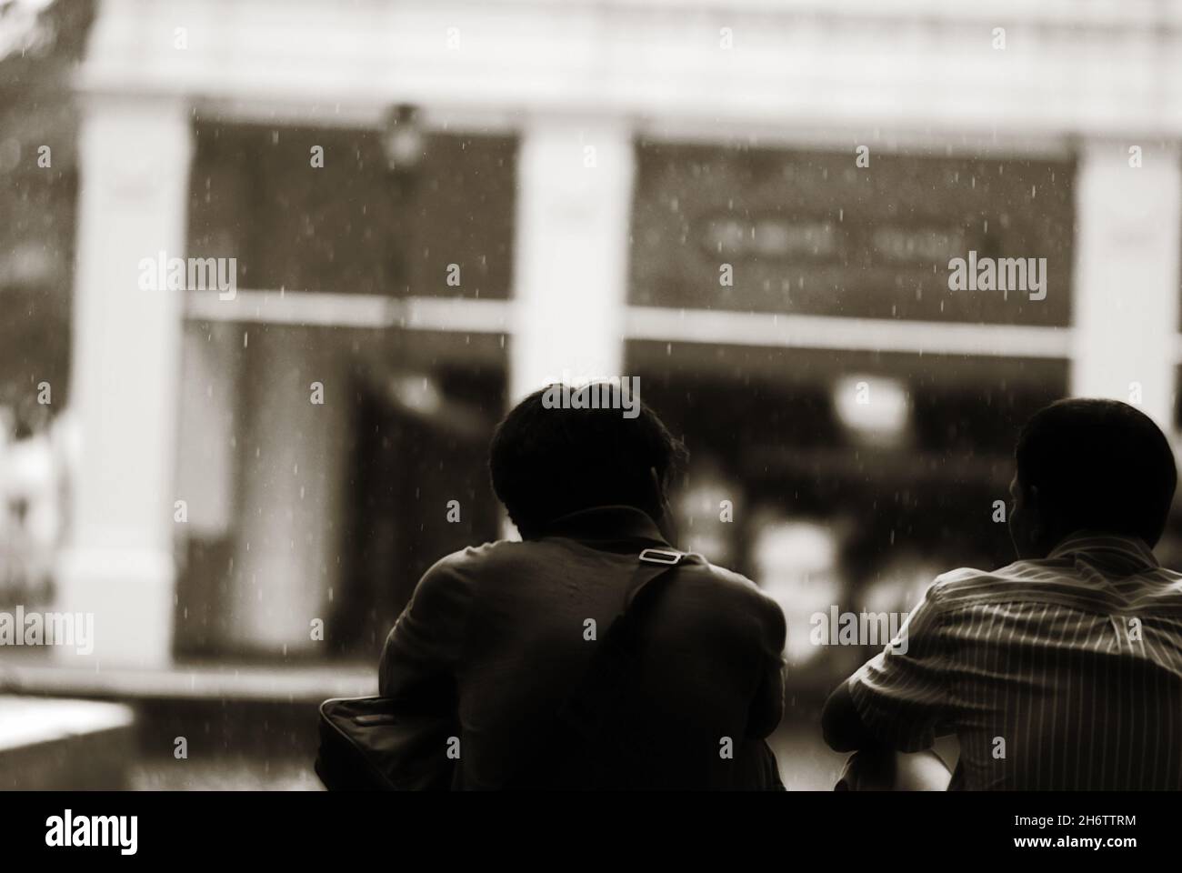 Greyscale back view of two passengers sitting on the floor Stock Photo ...