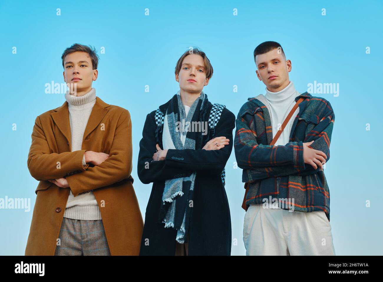 Three young men in casual clothes posing on the street Stock Photo - Alamy