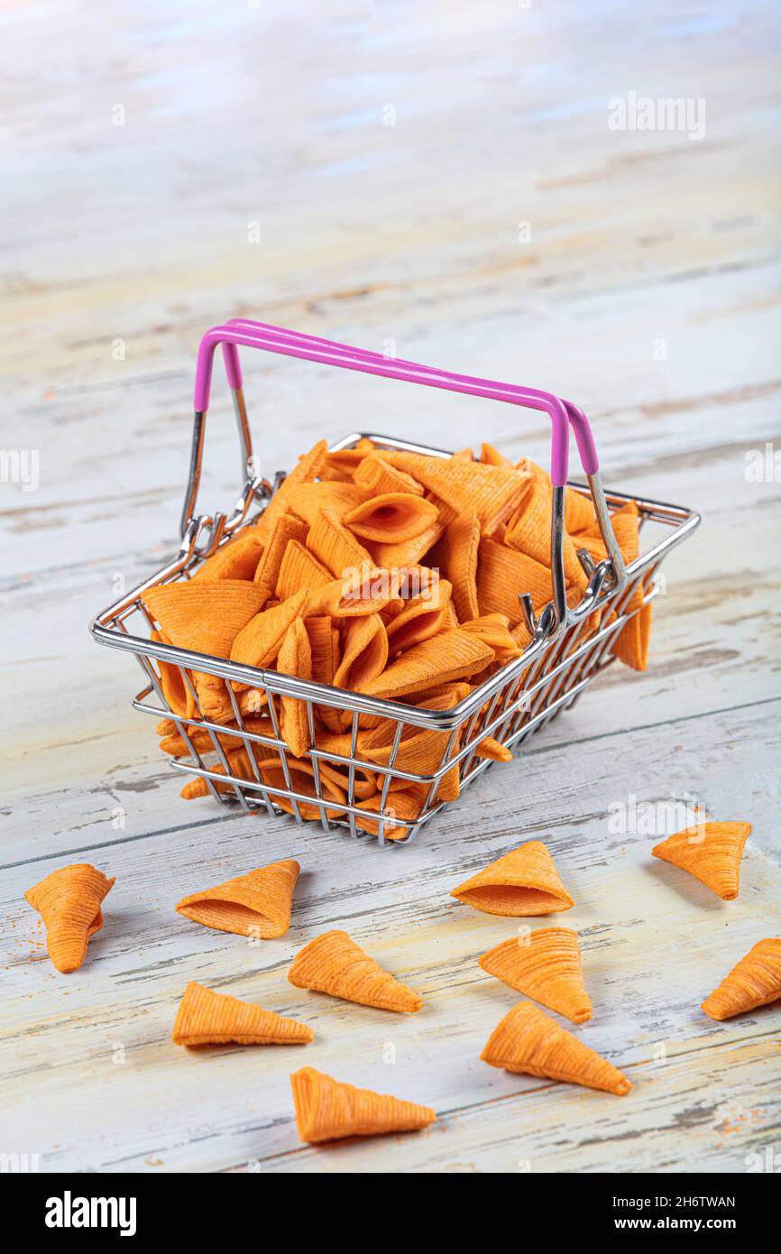 Portion of cone shaped snack tornado shaped crackers. Yellow spicy ...