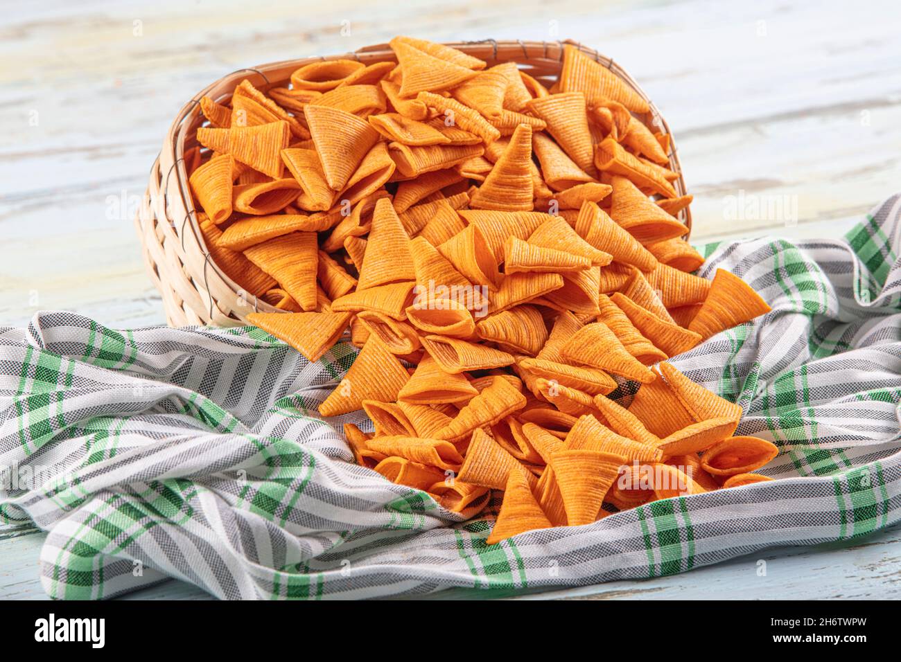 Portion of cone shaped snack tornado shaped crackers. Yellow spicy ...