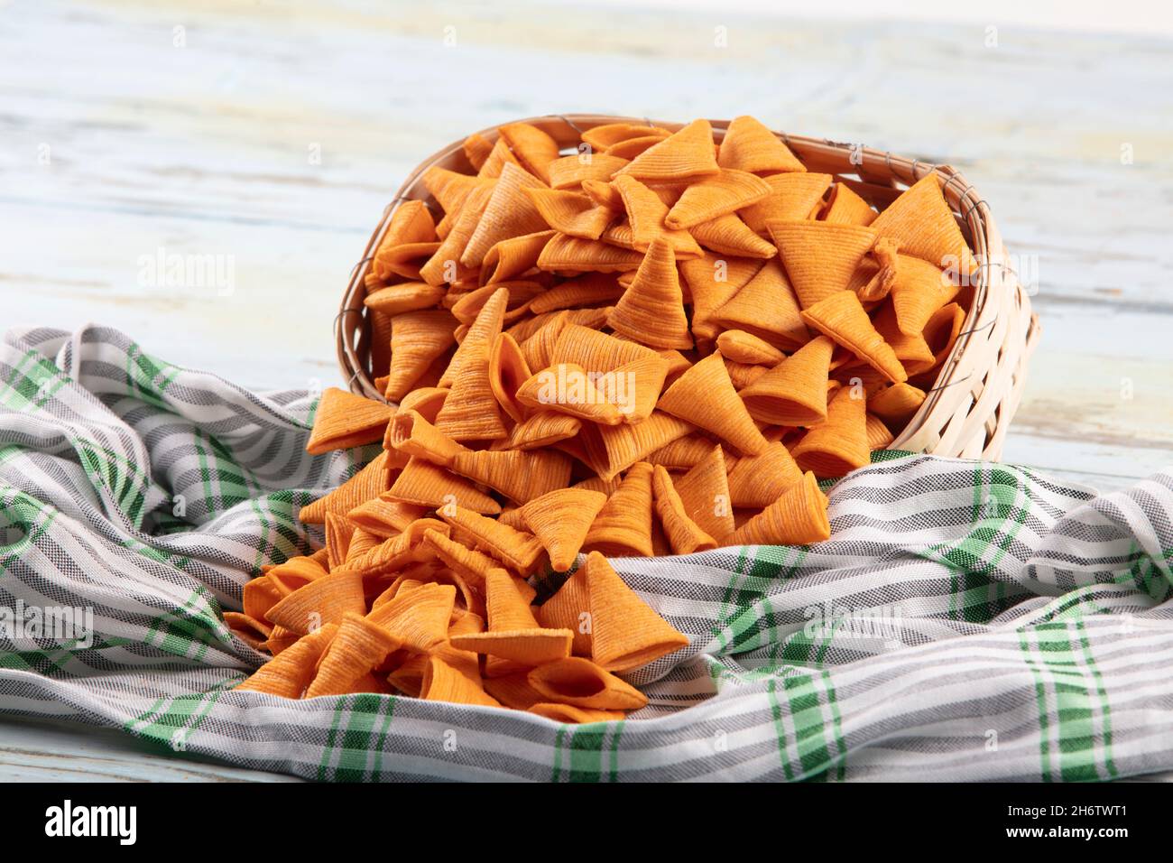 Portion of cone shaped snack tornado shaped crackers. Yellow spicy ...