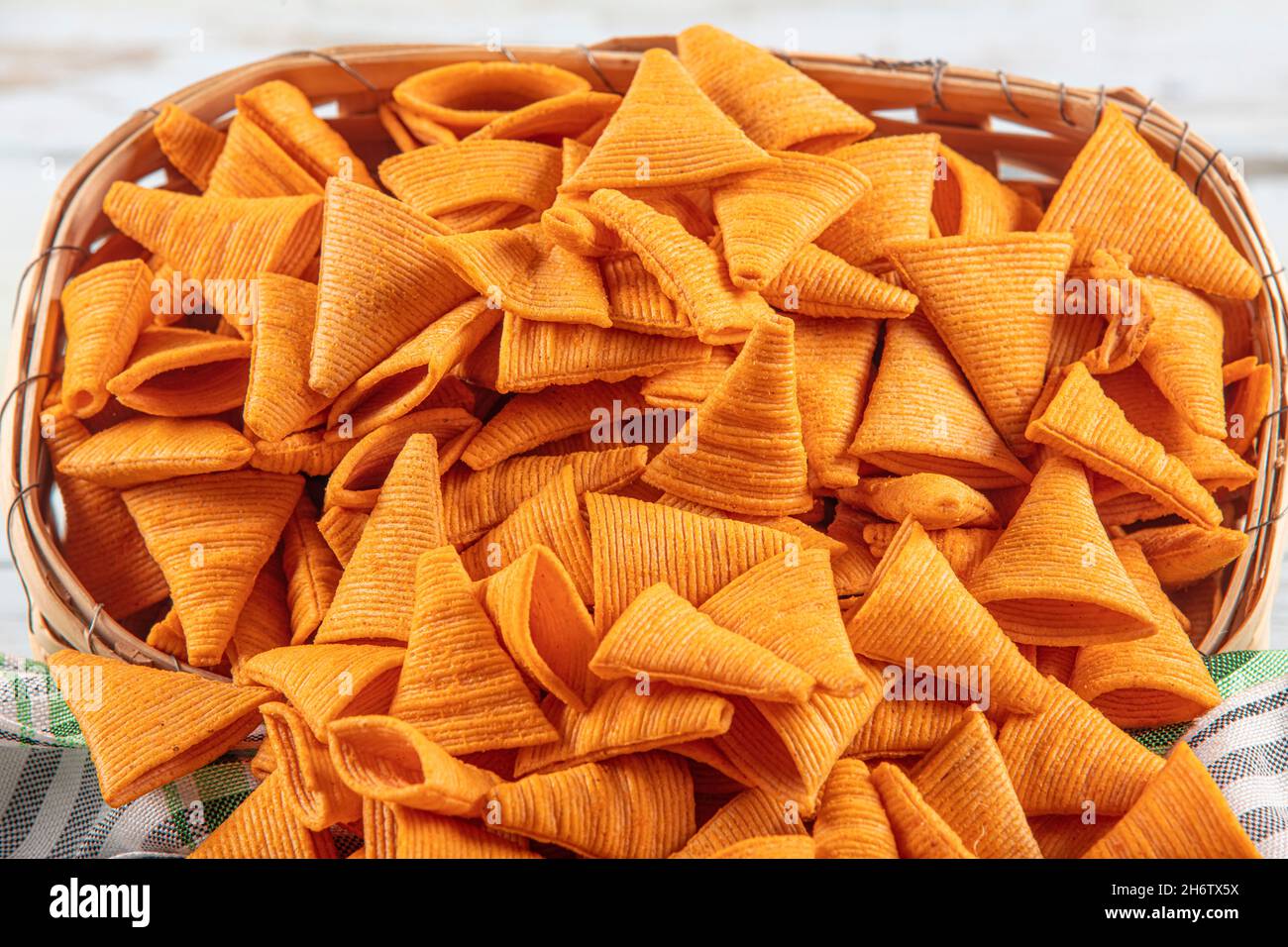 Portion of cone shaped snack tornado shaped crackers. Yellow spicy ...