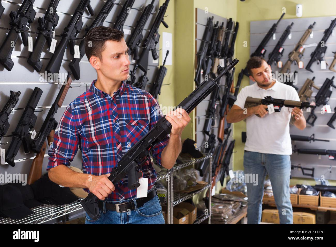 Friends choosing air-powered gun Stock Photo - Alamy