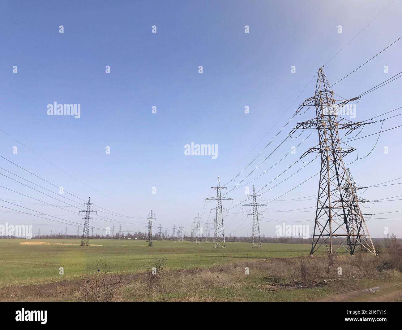 Electricity poles in a field. Electricity power concept Stock Photo - Alamy