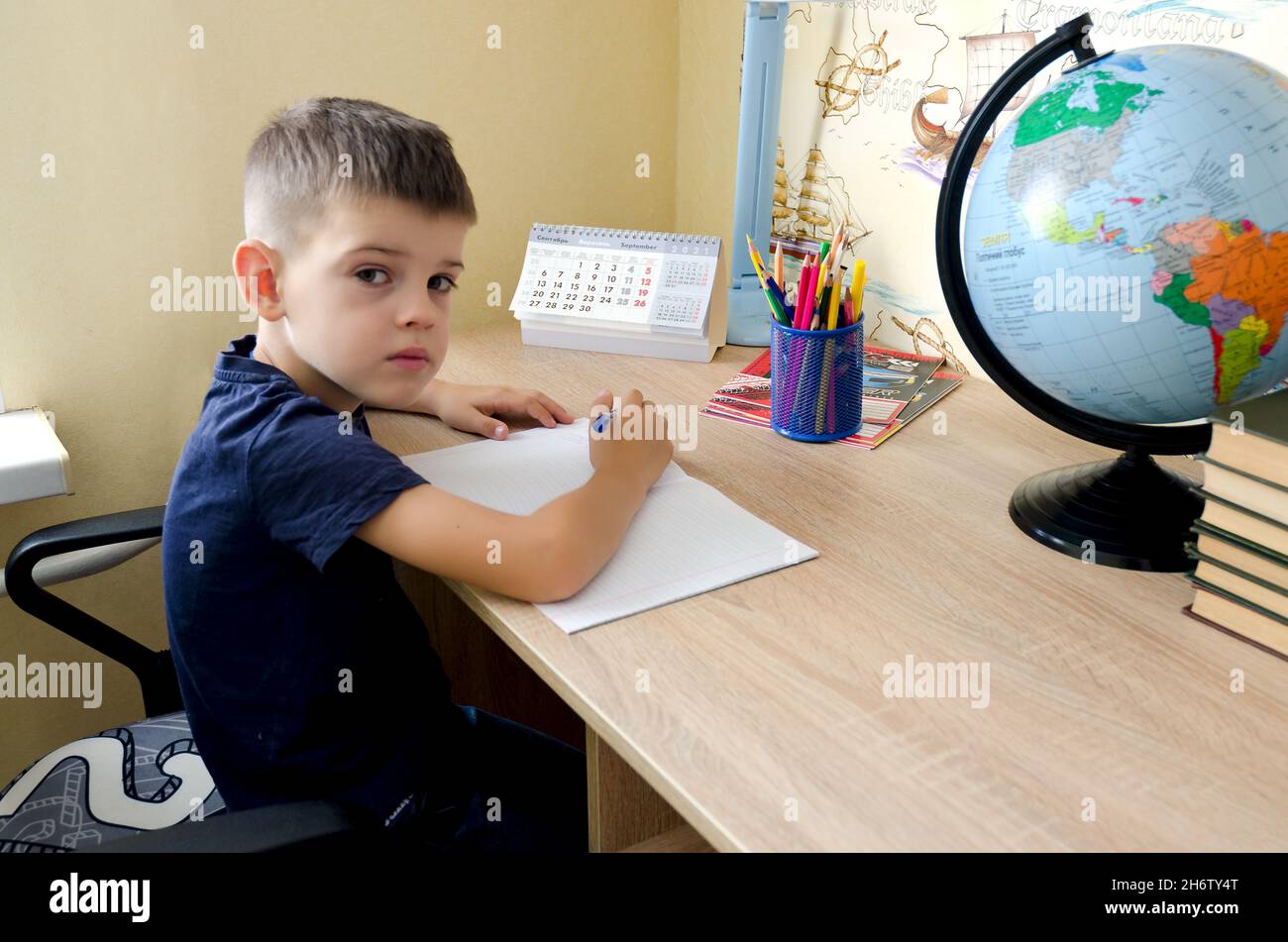 Back to school. Little tired boy doing homework at home with backpack ...