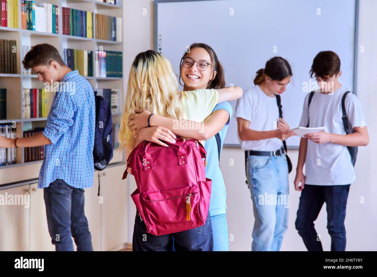 Students girls hugging at the meeting, group of teenagers in school ...