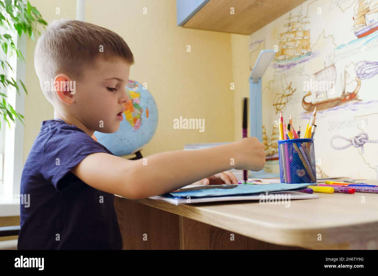 Back to school. Little tired boy doing homework at home with backpack ...
