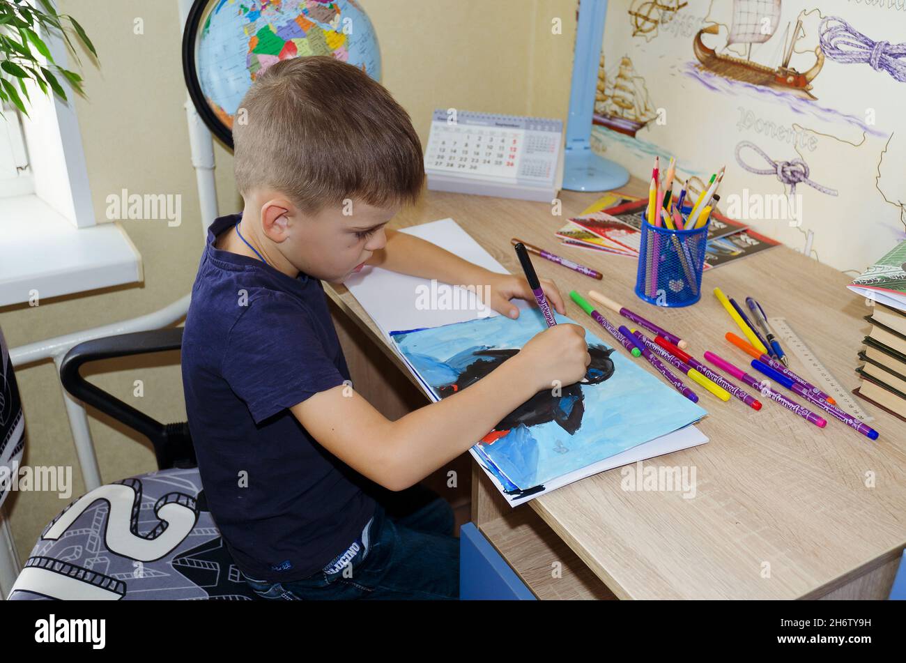 Back to school. Little tired boy doing homework at home with backpack ...