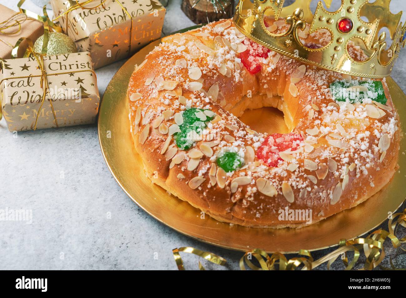 Roscon de reyes with cream and christmas ornaments on a table. Kings ...