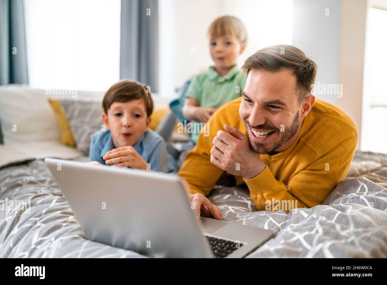 Happy family at home looking at laptop and having fun Stock Photo - Alamy