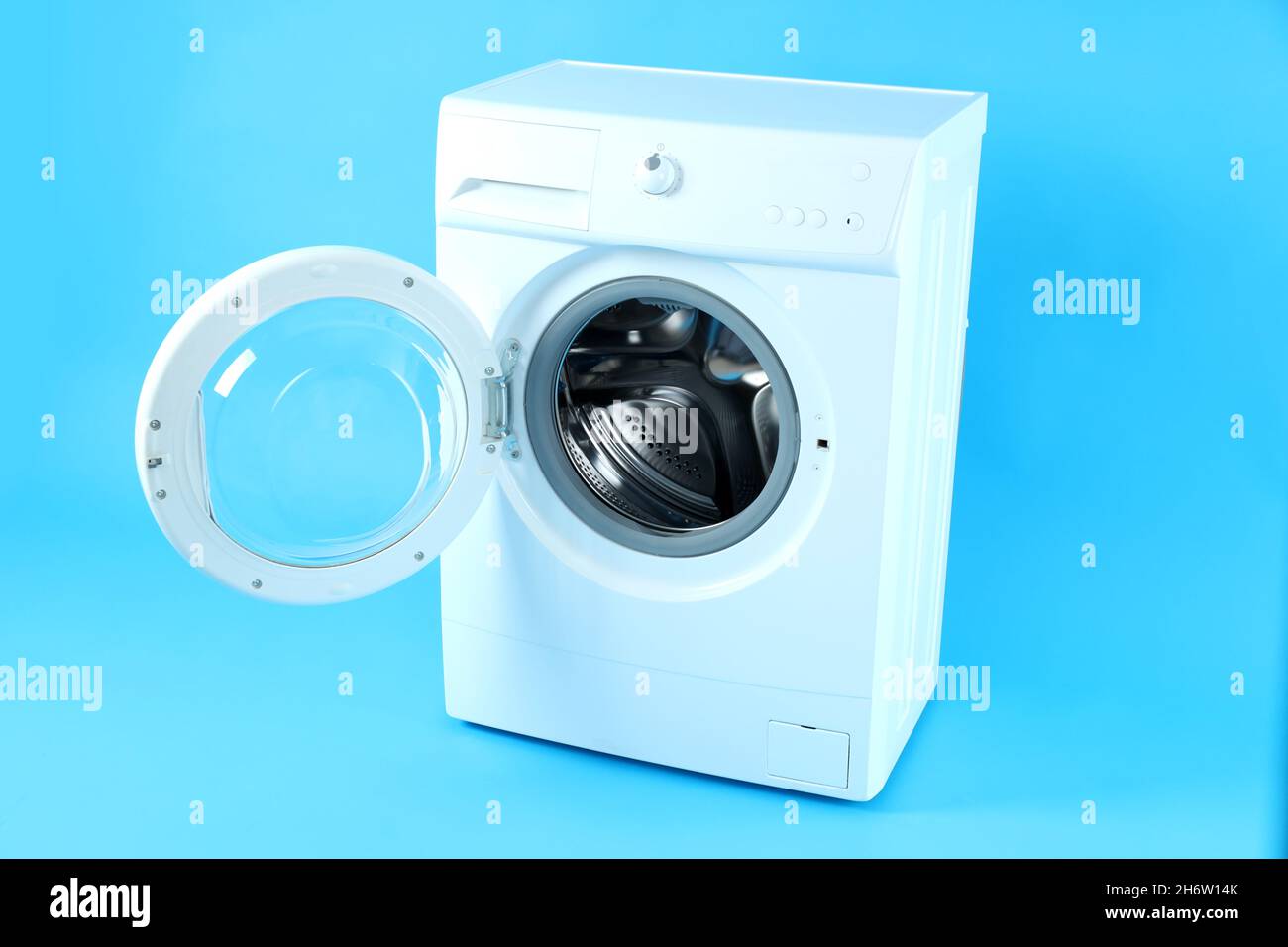 Modern white washing machine on blue background Stock Photo - Alamy
