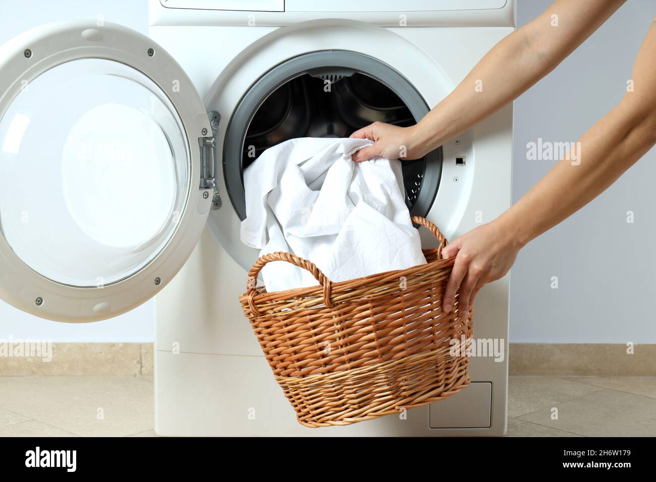 Concept of housework with washing machine against white wall Stock ...