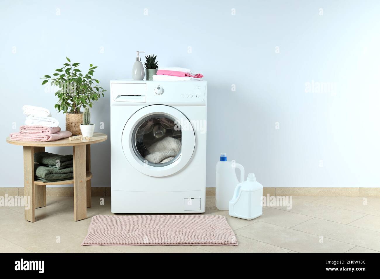 Concept of housework with washing machine against white wall Stock ...