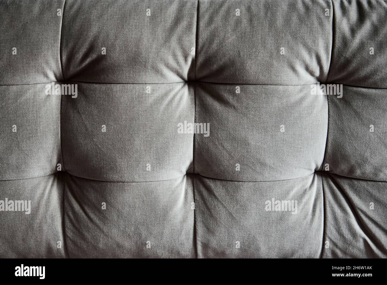 Gray couch surface background with buttons. Sofa pillow detail, close ...