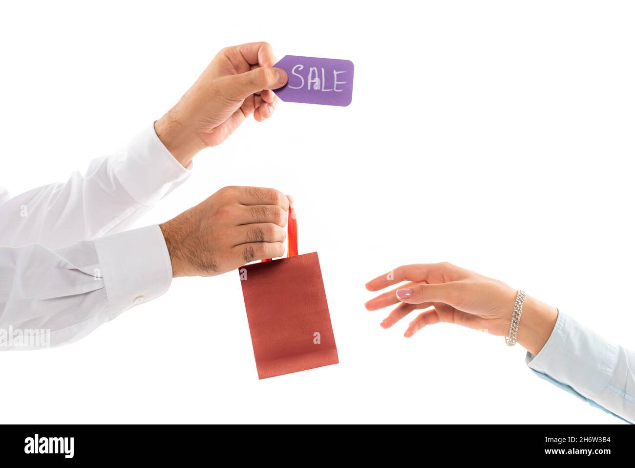cropped view of man holding shopping bag and price tag near female hand ...