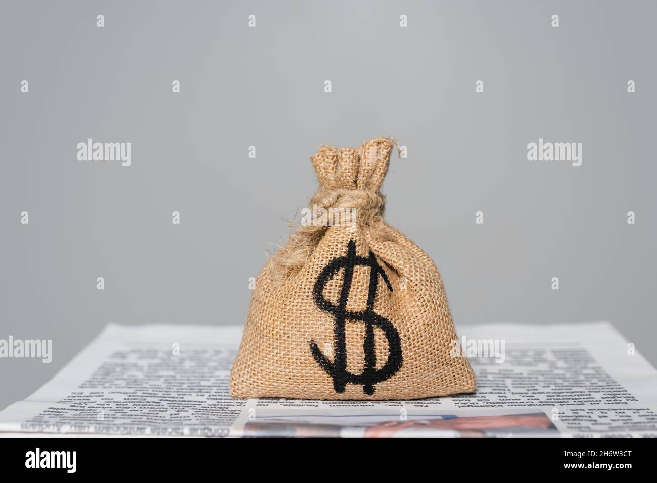 money bag with dollar sign on newspaper isolated on grey Stock Photo ...