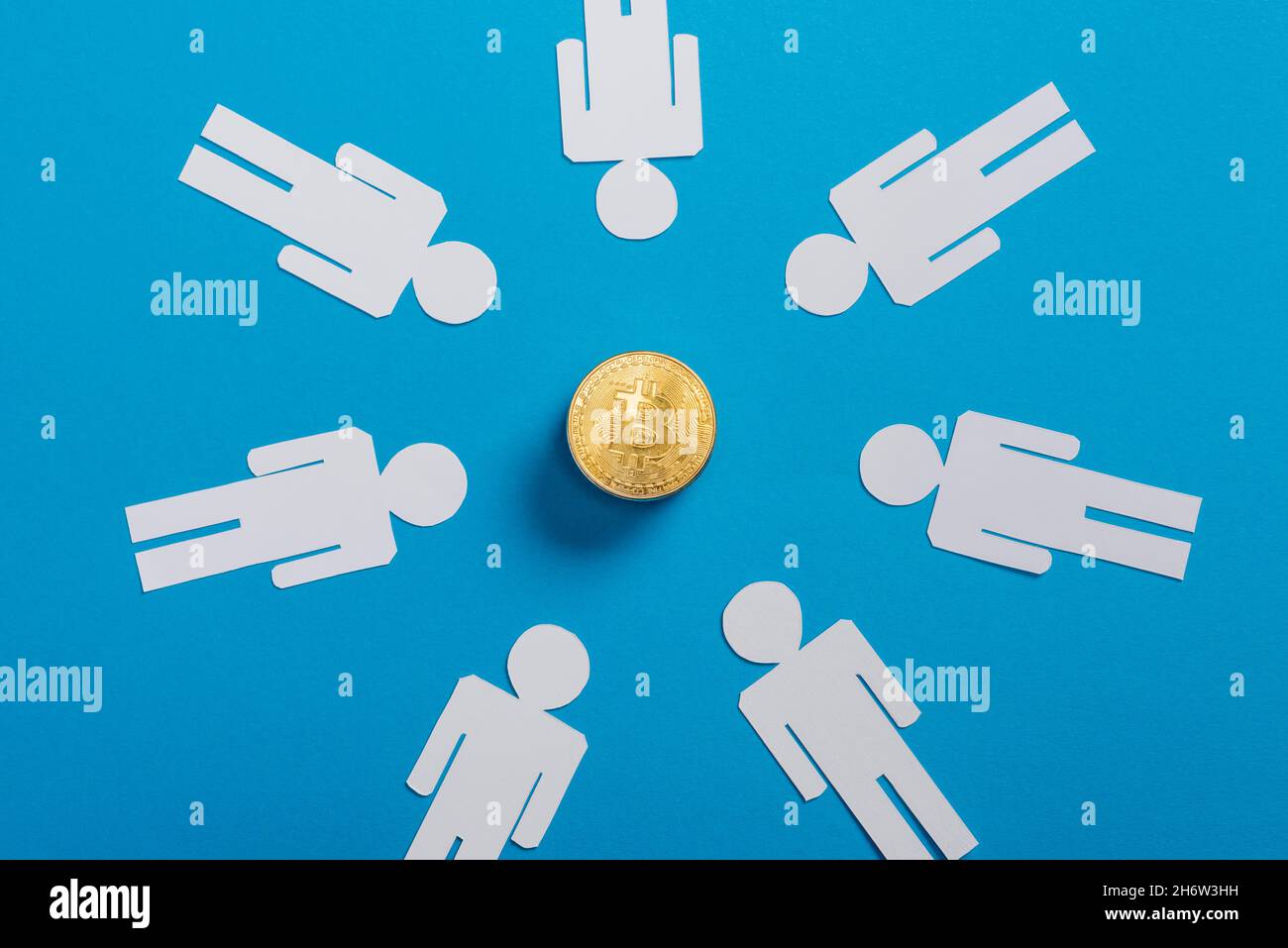 top view of white paper cut people in circle near golden bitcoin on ...