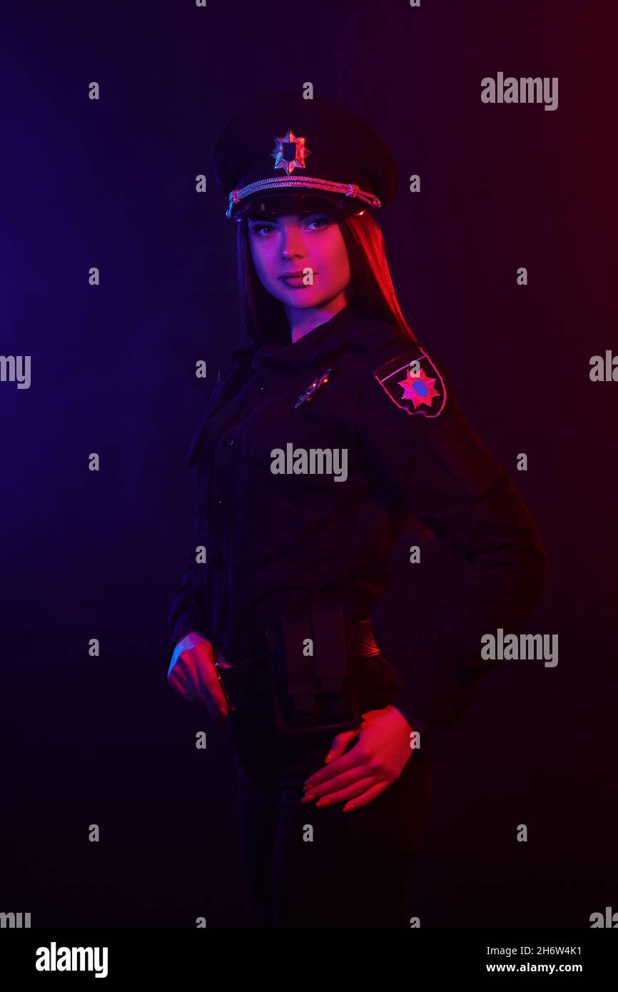 Redheaded female police officer is posing for the camera against a ...