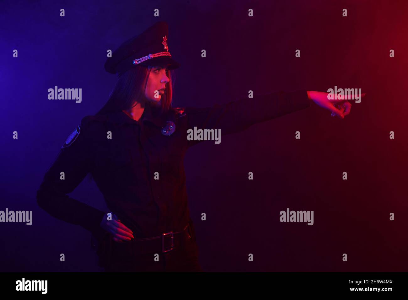 Redheaded female police officer is posing for the camera against a ...