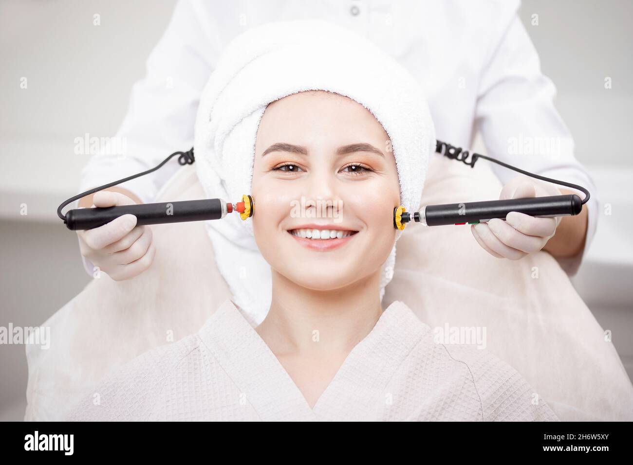 Young woman having stimulation microcurrent procedure for lifting skin ...