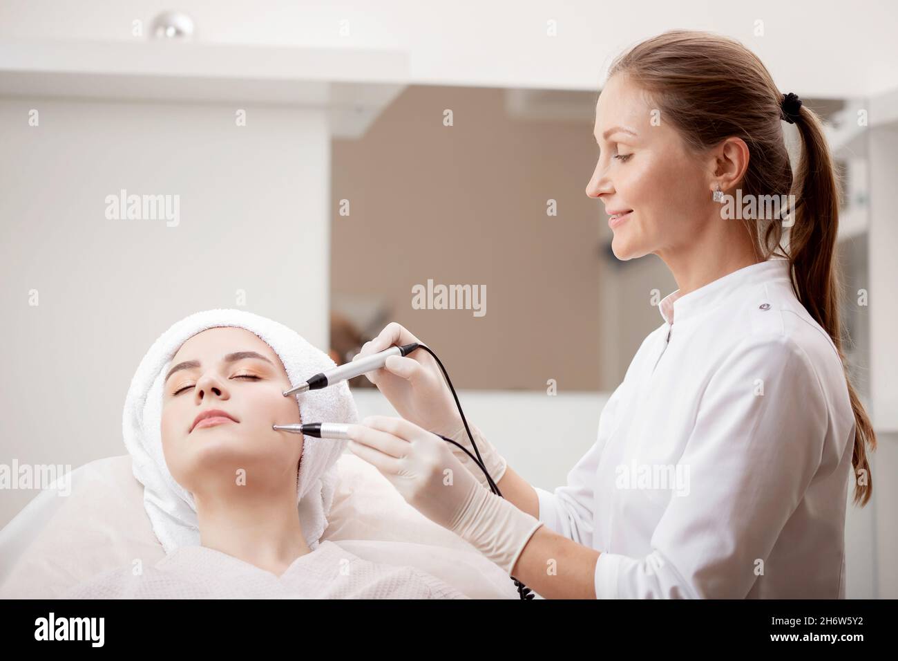 Young woman having stimulation microcurrent procedure for lifting skin ...