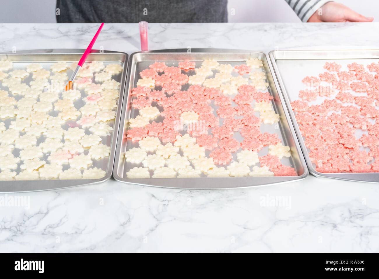 Brushing food glitter on top of small chocolate snowflakes Stock Photo ...