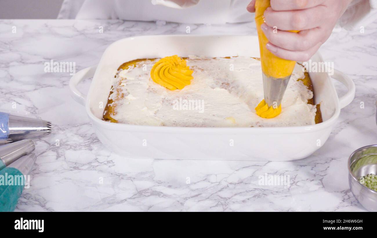 Piping rosettes with Italian buttercream frosting on top of sheet cake ...