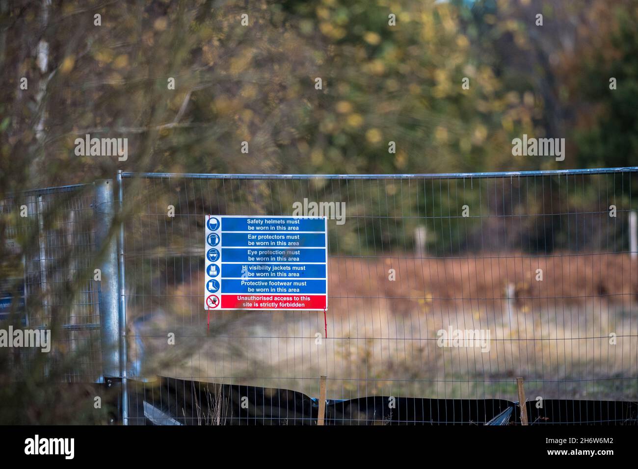 Metal fence and safety signs surround a contaminated heathland used for ...