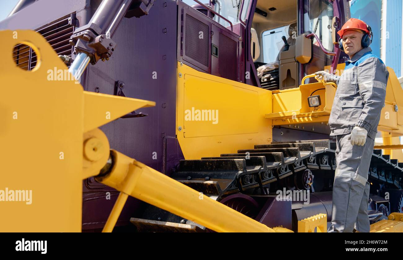 Industrial bulldozer driver gets into coal loading cab in open pit mine ...