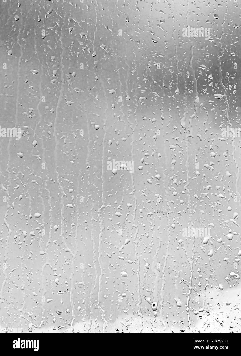 Rain drops on window glasses surface with gray sky background. Natural ...