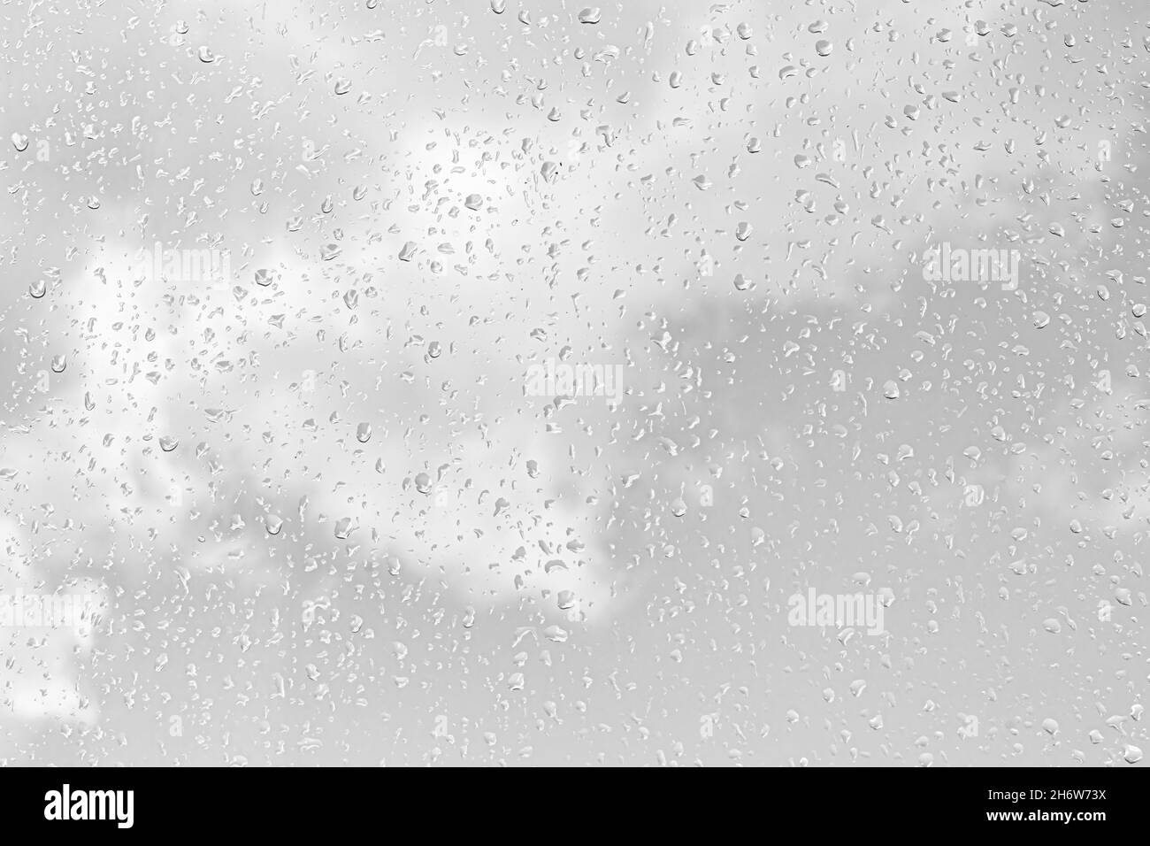 Rain drops on window glasses surface with gray sky background. Natural ...