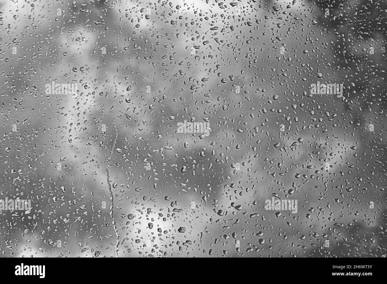 Rain drops on window glasses surface with gray sky background. Natural ...