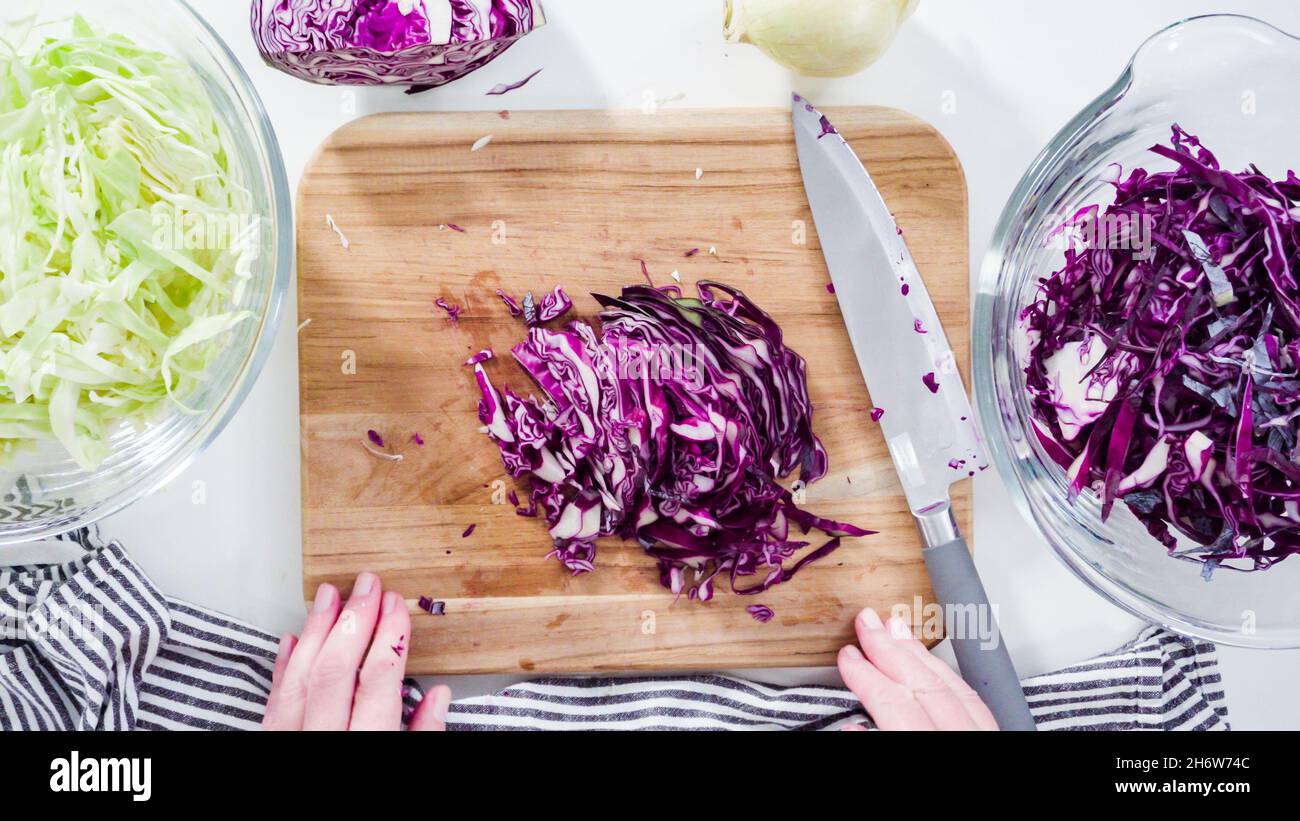 Flat lay. Step by step. Shredding organic cabbage on a wood cutting ...