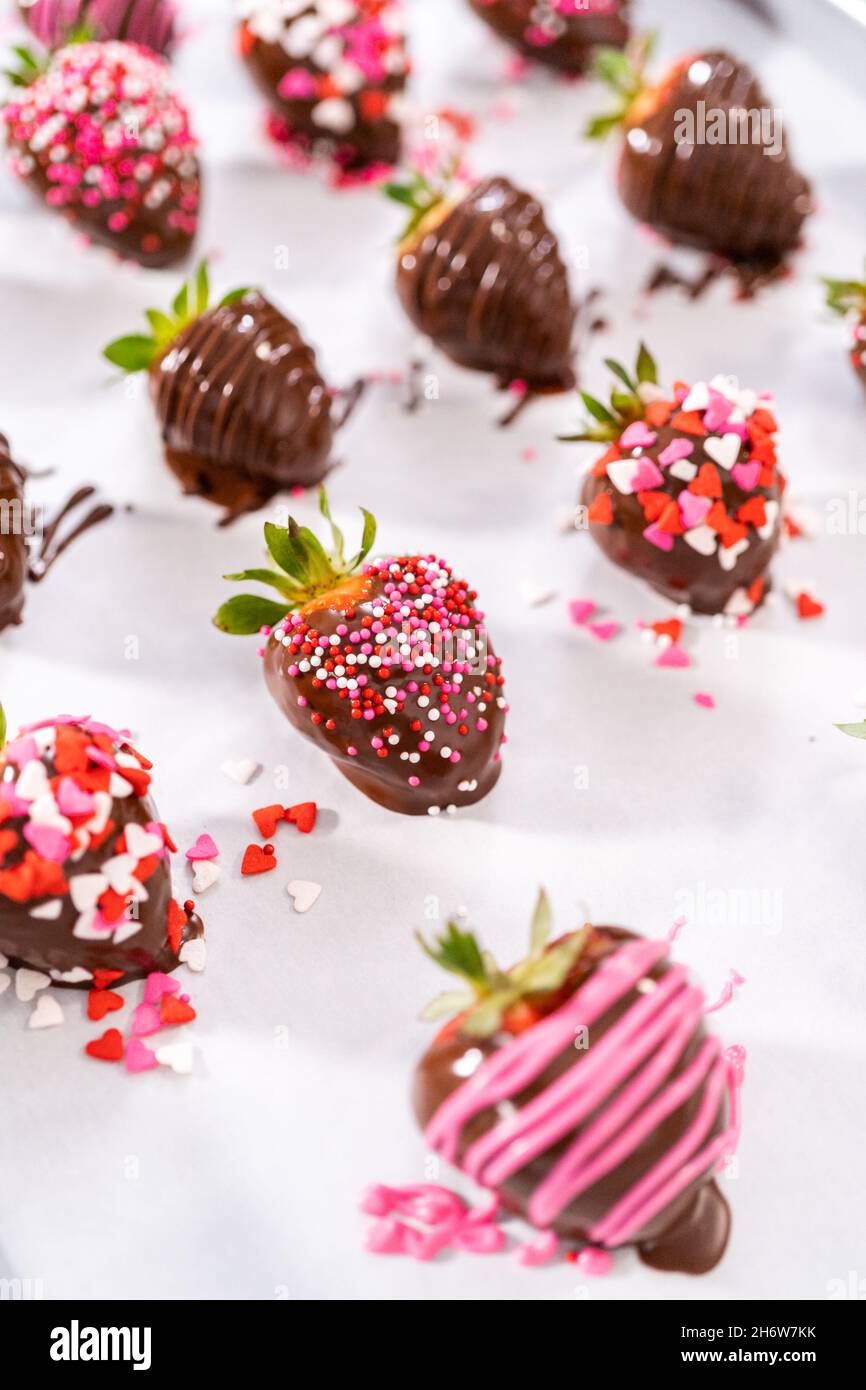 Decorating chocolate-covered strawberries with chocolate drizzles and ...