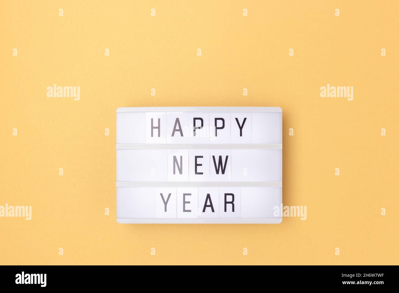 Happy New Year. White lightbox with phrase on a golden background with ...