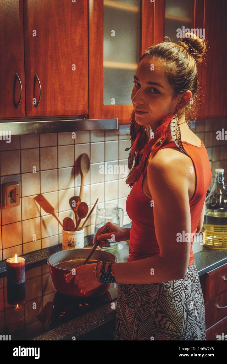 beautiful woman boiling cocoa in the kitchen Stock Photo - Alamy