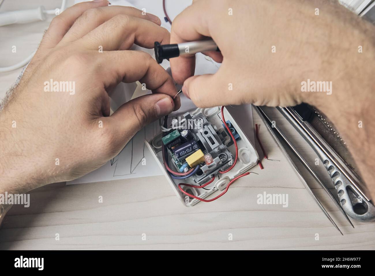 Repair of electronic devices, tin soldering parts. Hands of man holding ...