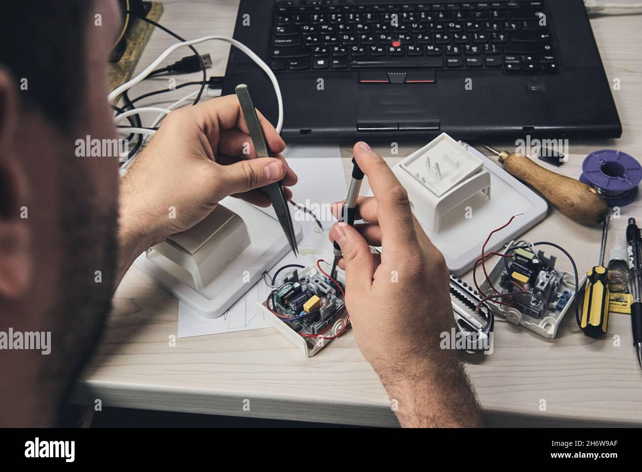 Repair of electronic devices, tin soldering parts. Hands of man holding ...