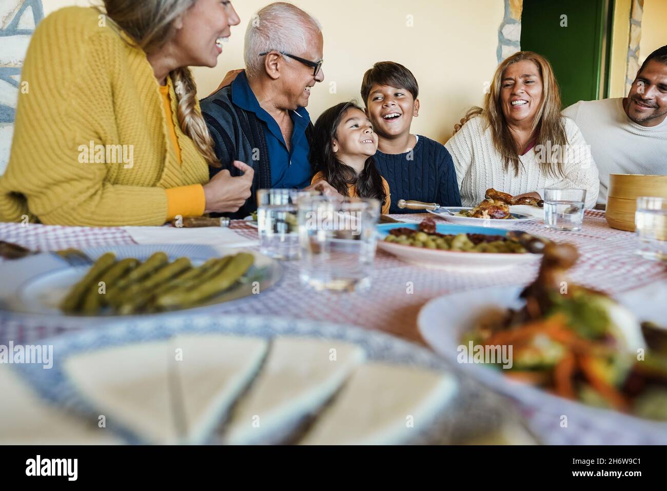 Happy latin family having fun eating together at home - Focus on ...