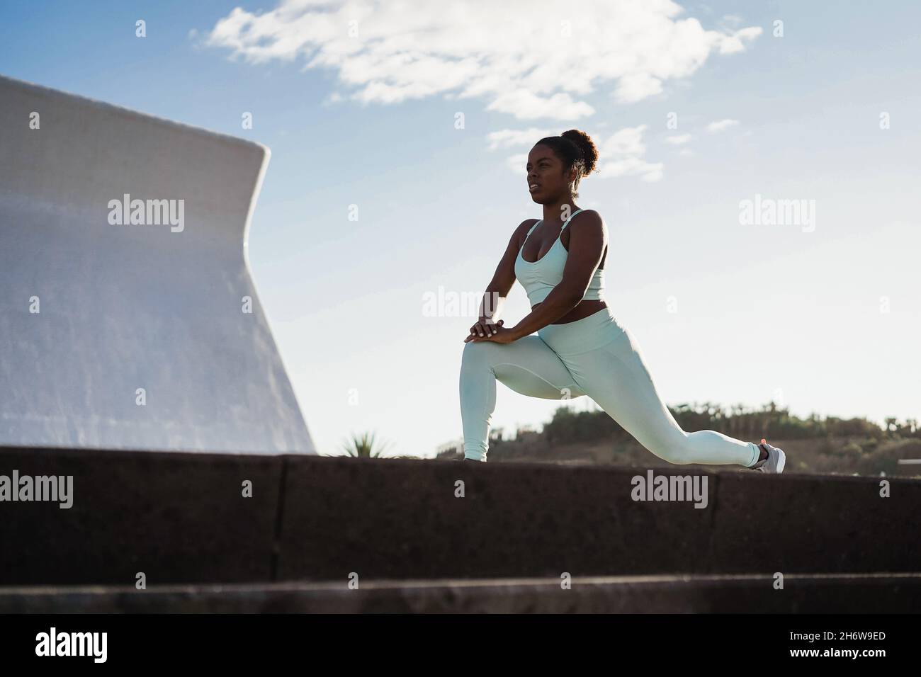 Fit african woman doing sport stretching exercise outdoor in the city ...